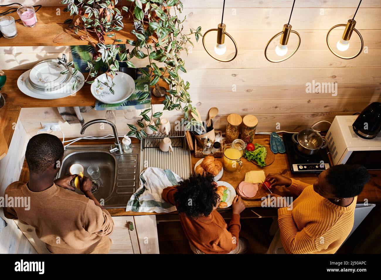 View of young African American family of three preparing food for ...