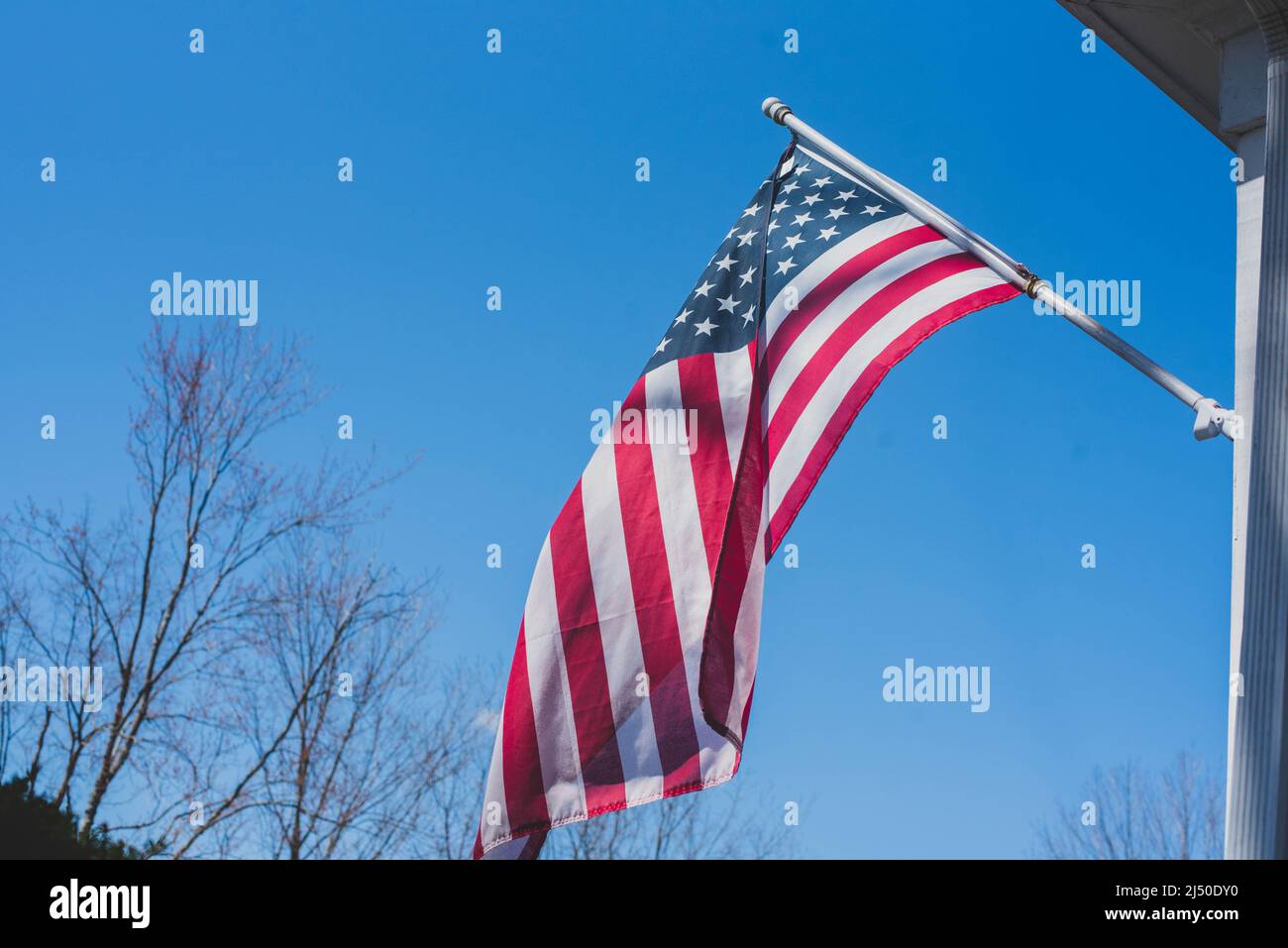 American flag flying outside a home Stock Photo - Alamy