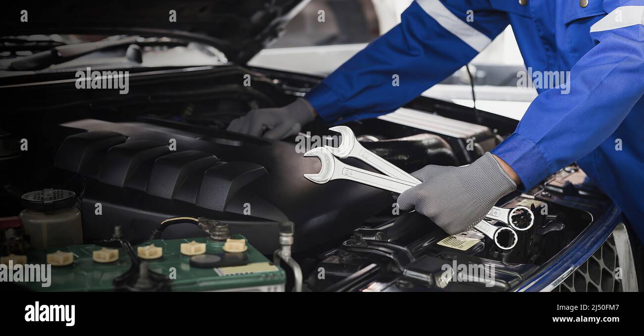 Car mechanic working on car engine, car maintenance concept Stock Photo ...