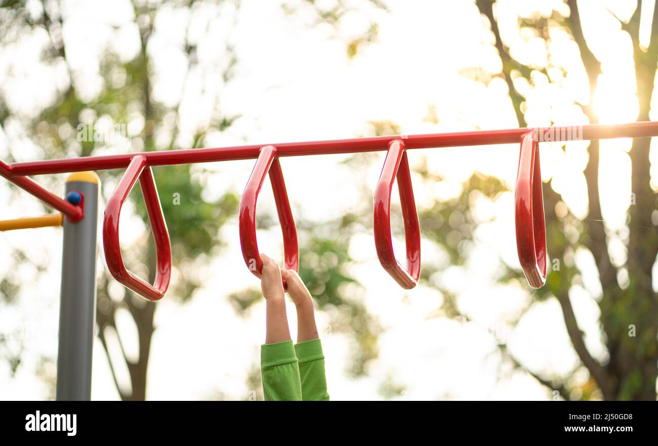 Kid playing on a children playground equipment, outdoor. Close up view ...