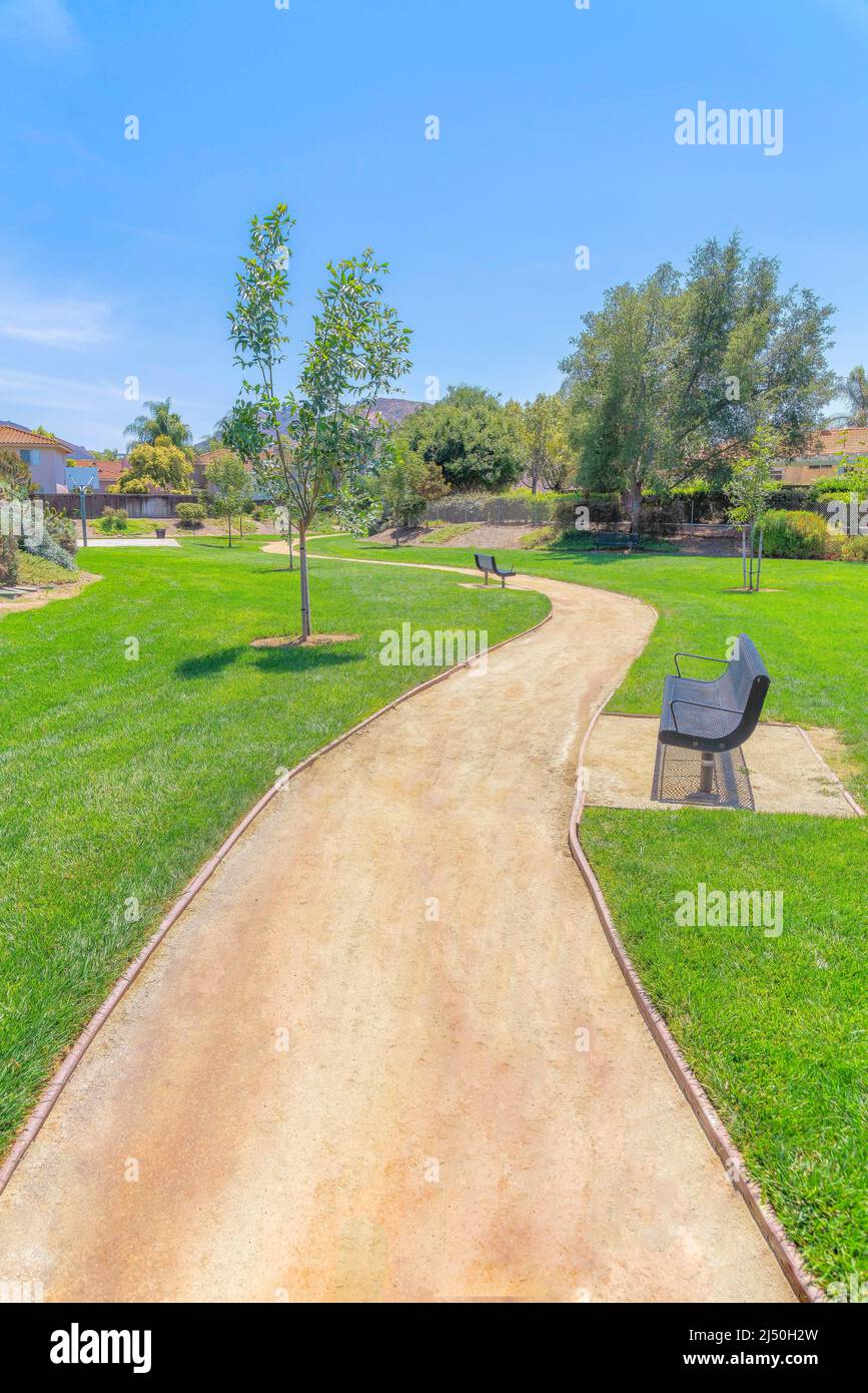 Dirt flat trail with benches and trees on the side at San Diego ...