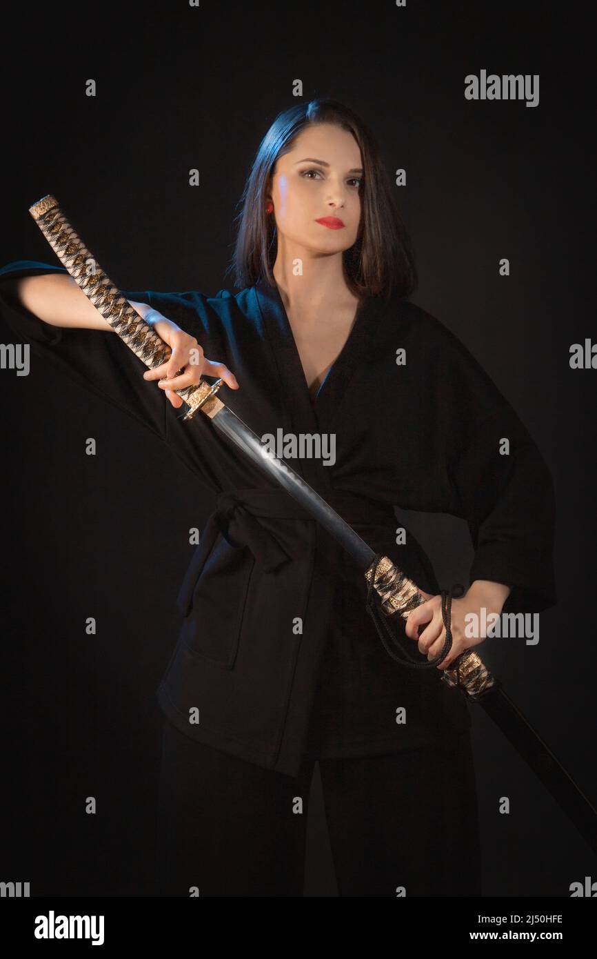 Mysterious young beautiful woman with a sharp sword in Asian style ...