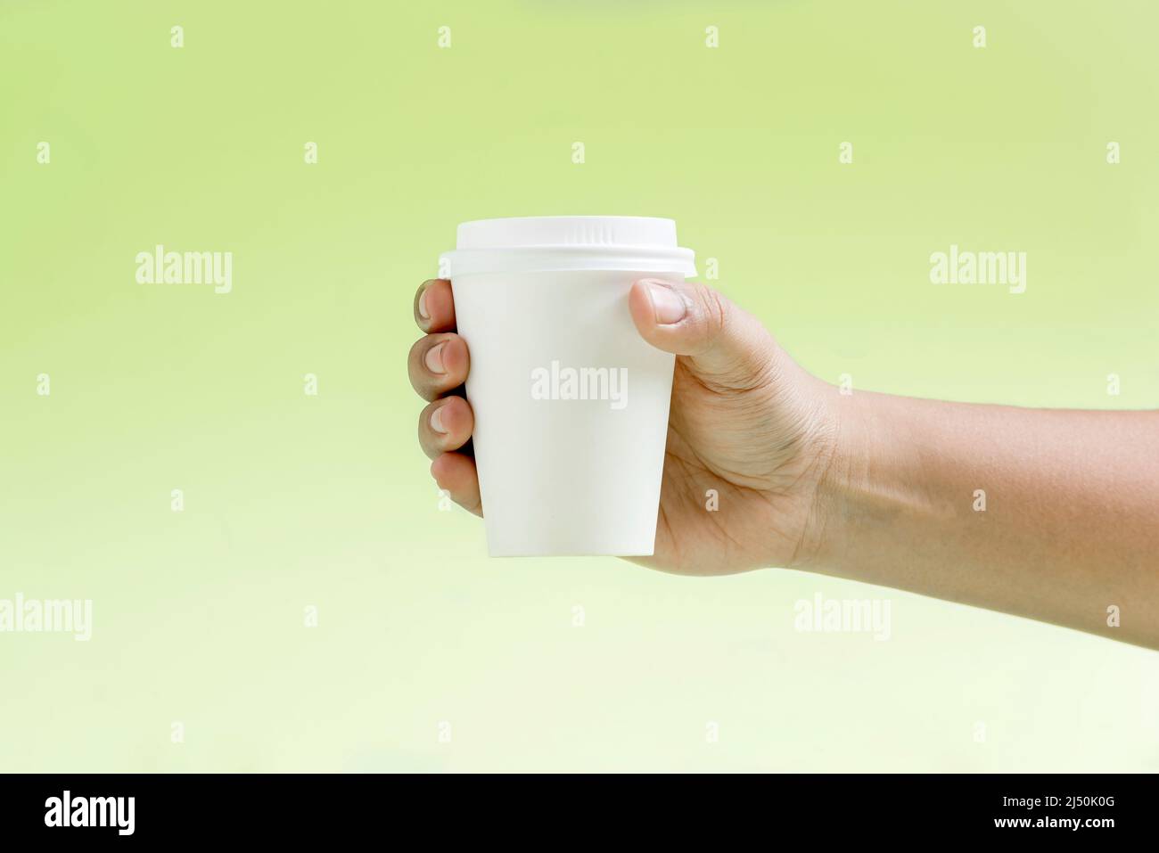 Human hand holding a white plastic cup with colored background Stock ...