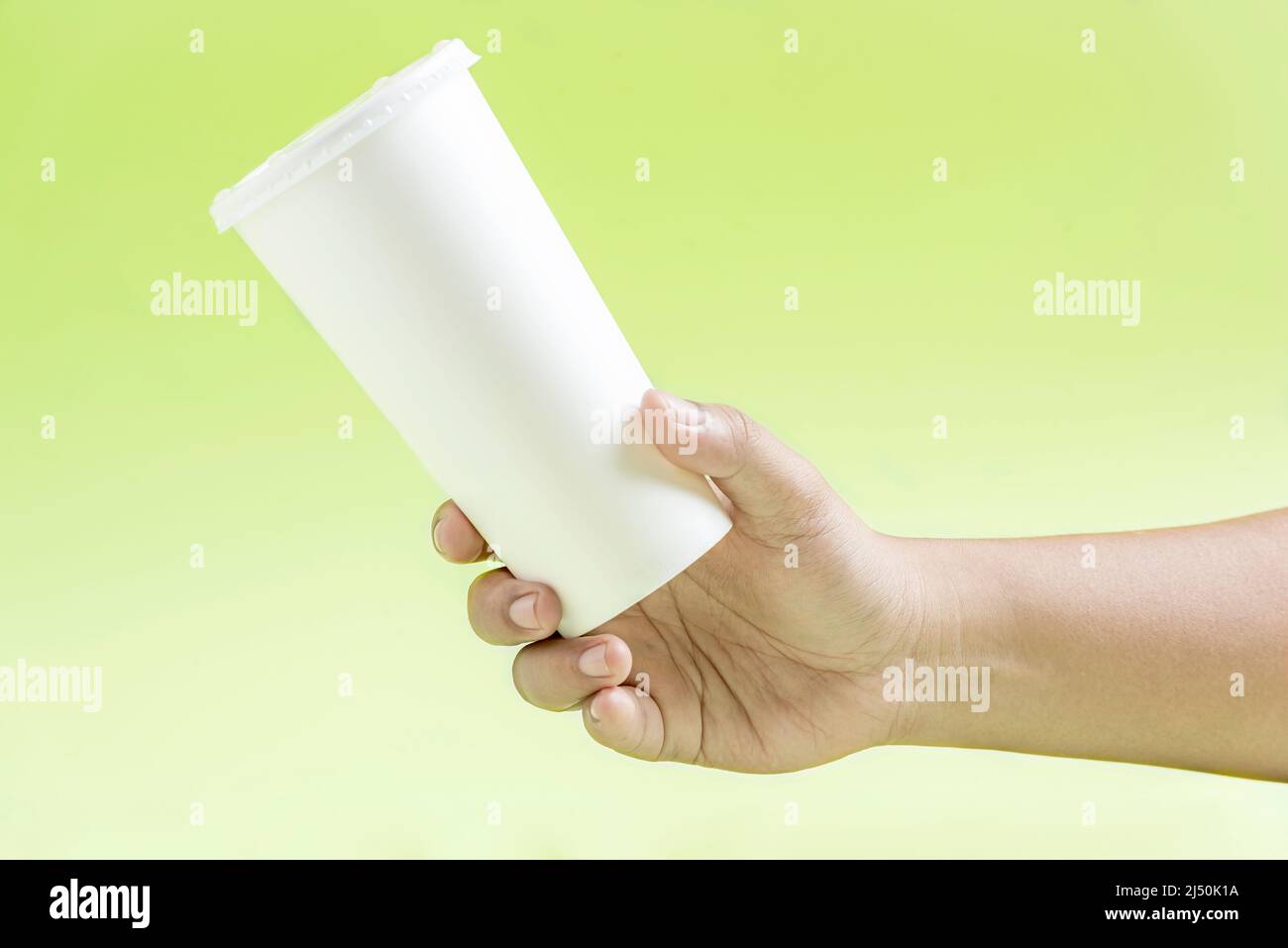 Human hand holding a white plastic cup with colored background Stock ...