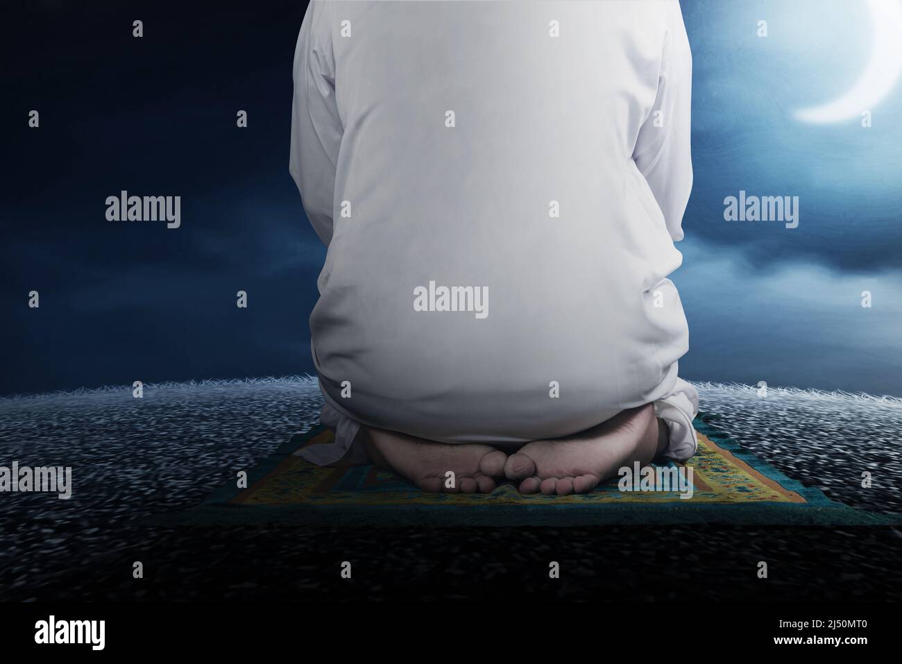 Close up view of a Muslim man in a praying position (salat) on a prayer ...