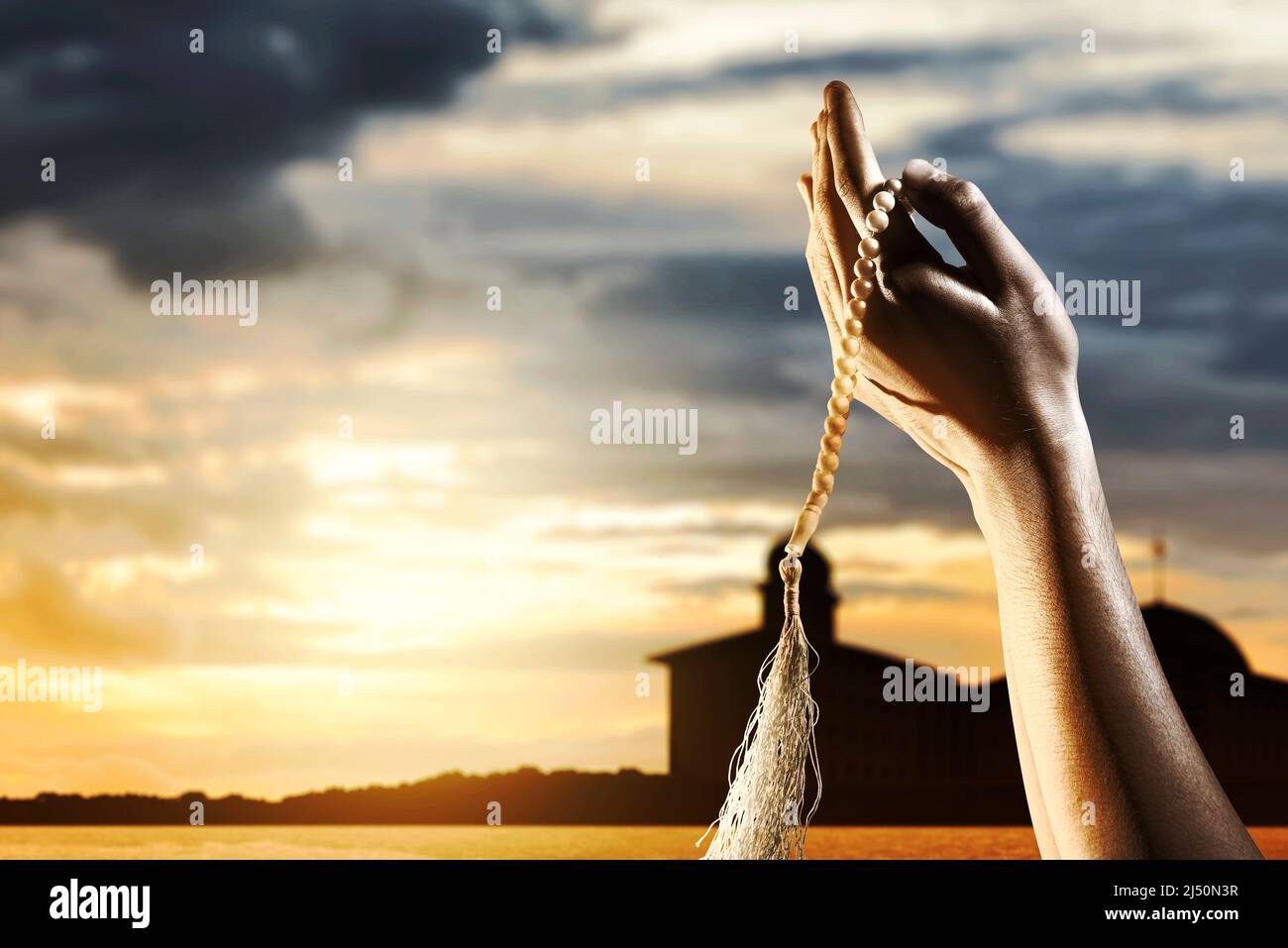 Muslim man praying with prayer beads in his hands with the dramatic ...
