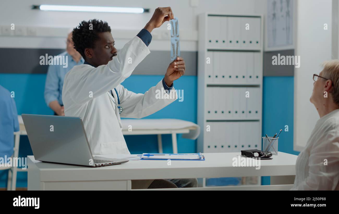 Medic of african american ethnicity analyzing x ray of patient ...