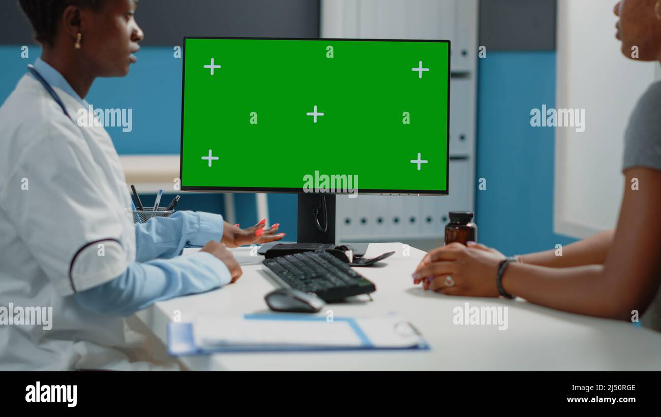 Close up of computer with horizontal green screen on desk. Doctor and ...
