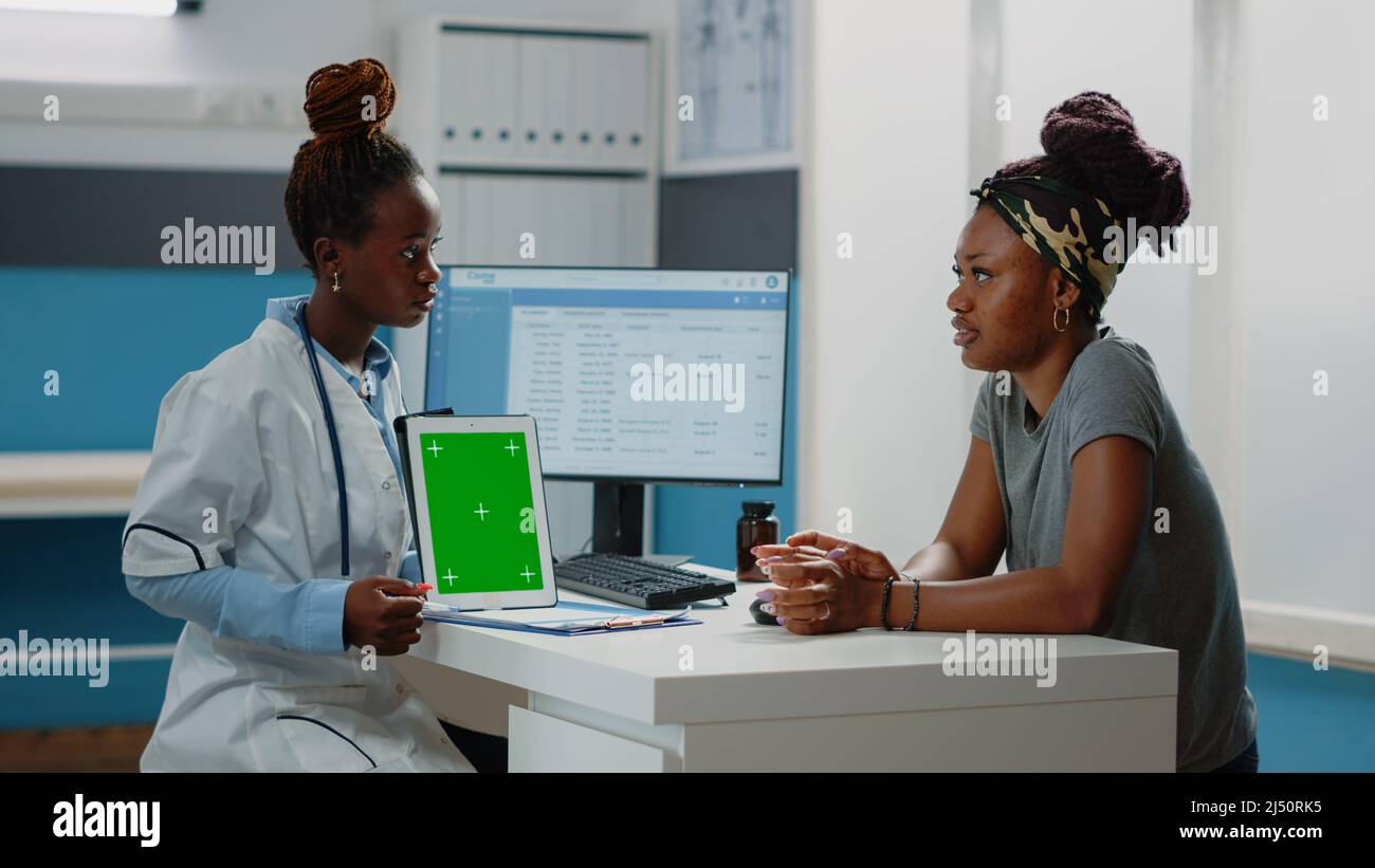 African american doctor and patient looking at green screen on tablet ...