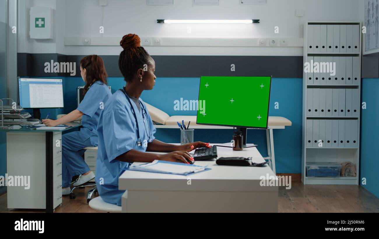 Medical assistant using computer with horizontal green screen in ...