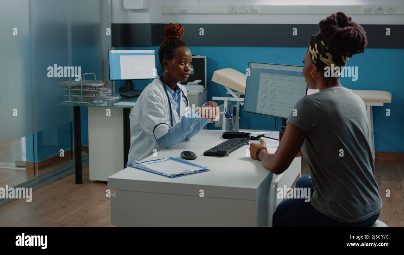 Woman working as doctor talking to patient about sickness in doctors ...