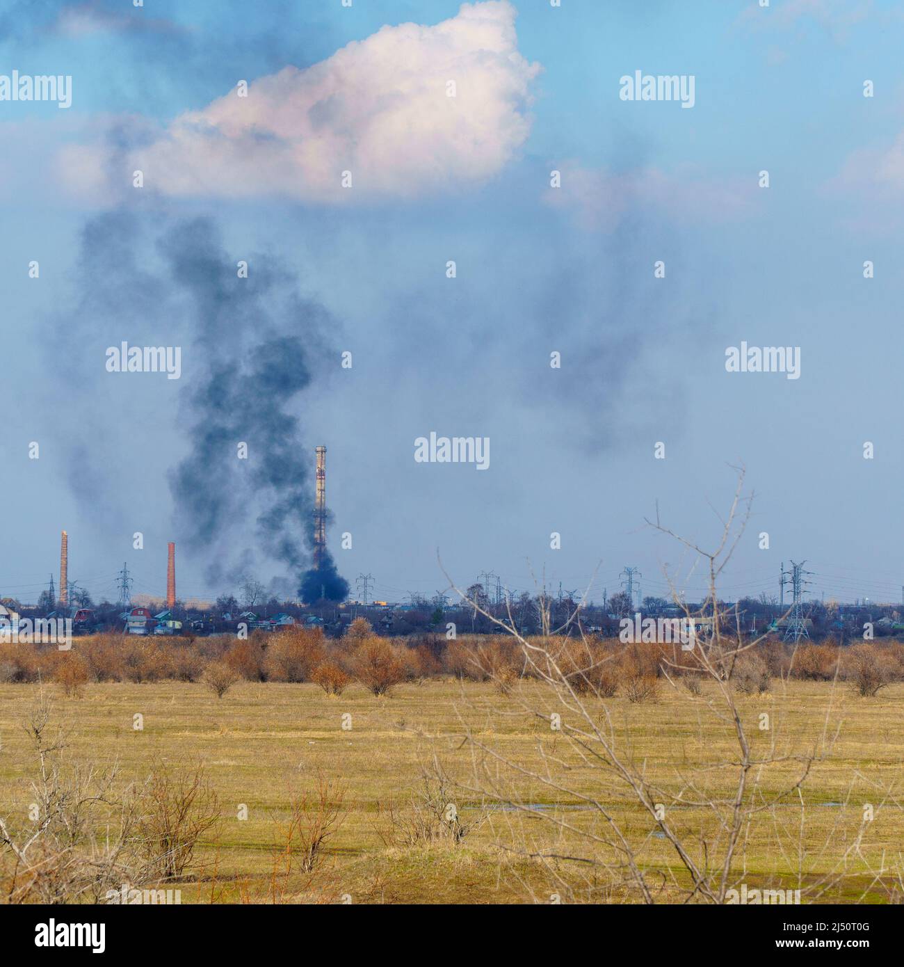 Smoke from a fire in the distance behind the field Stock Photo - Alamy