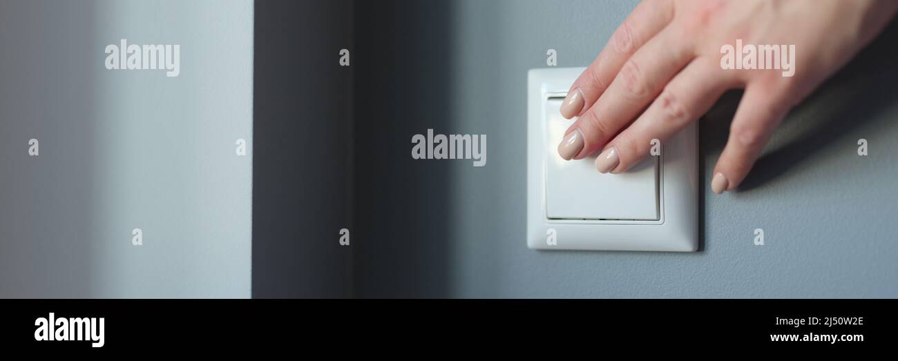 Female hand pressing light switch in apartment closeup Stock Photo - Alamy