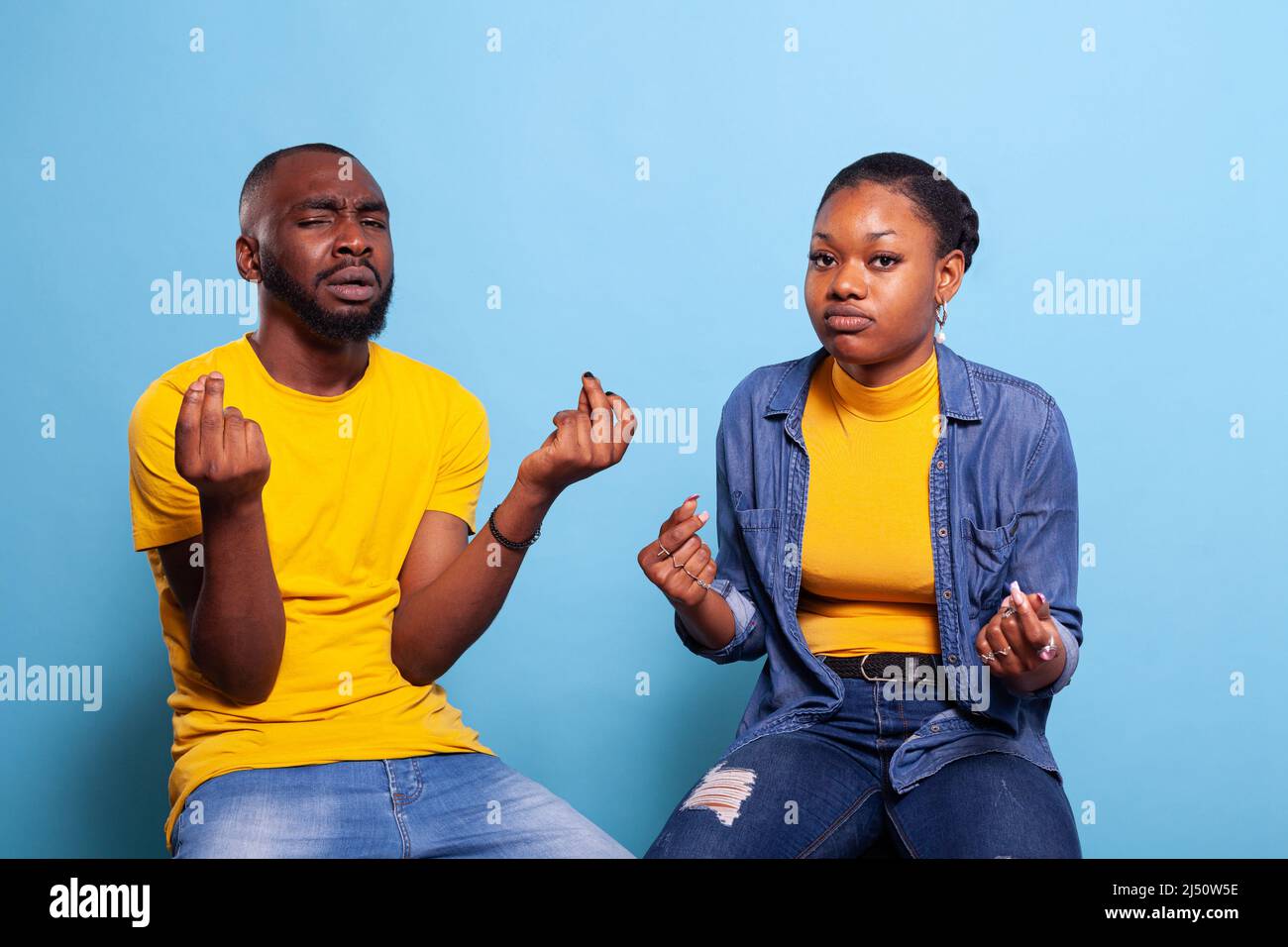 Couple doing money gesture and demanding cash reward while they sit in ...