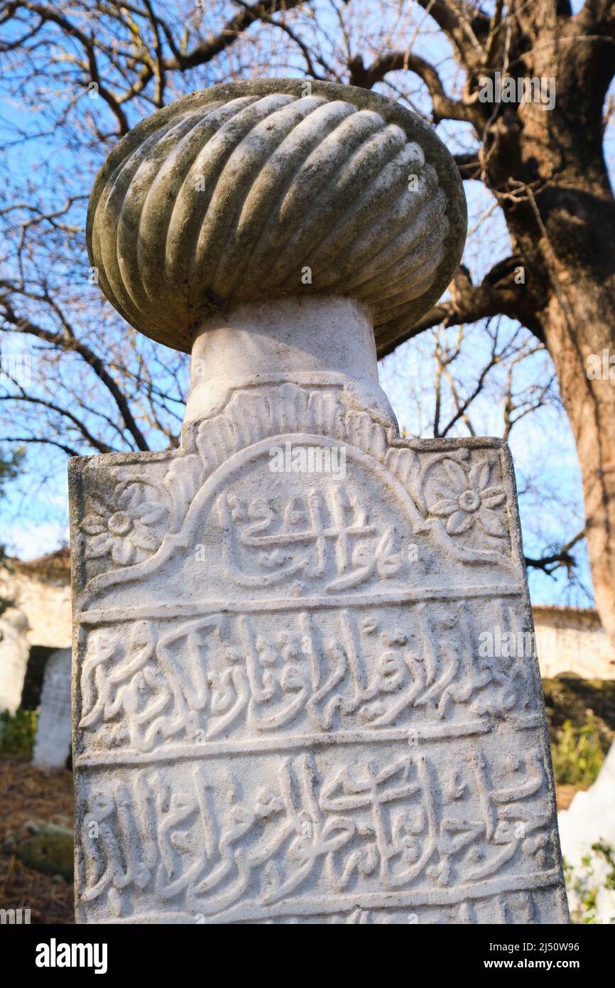 An old, traditional, stone headstone, grave featuring a turban top ...