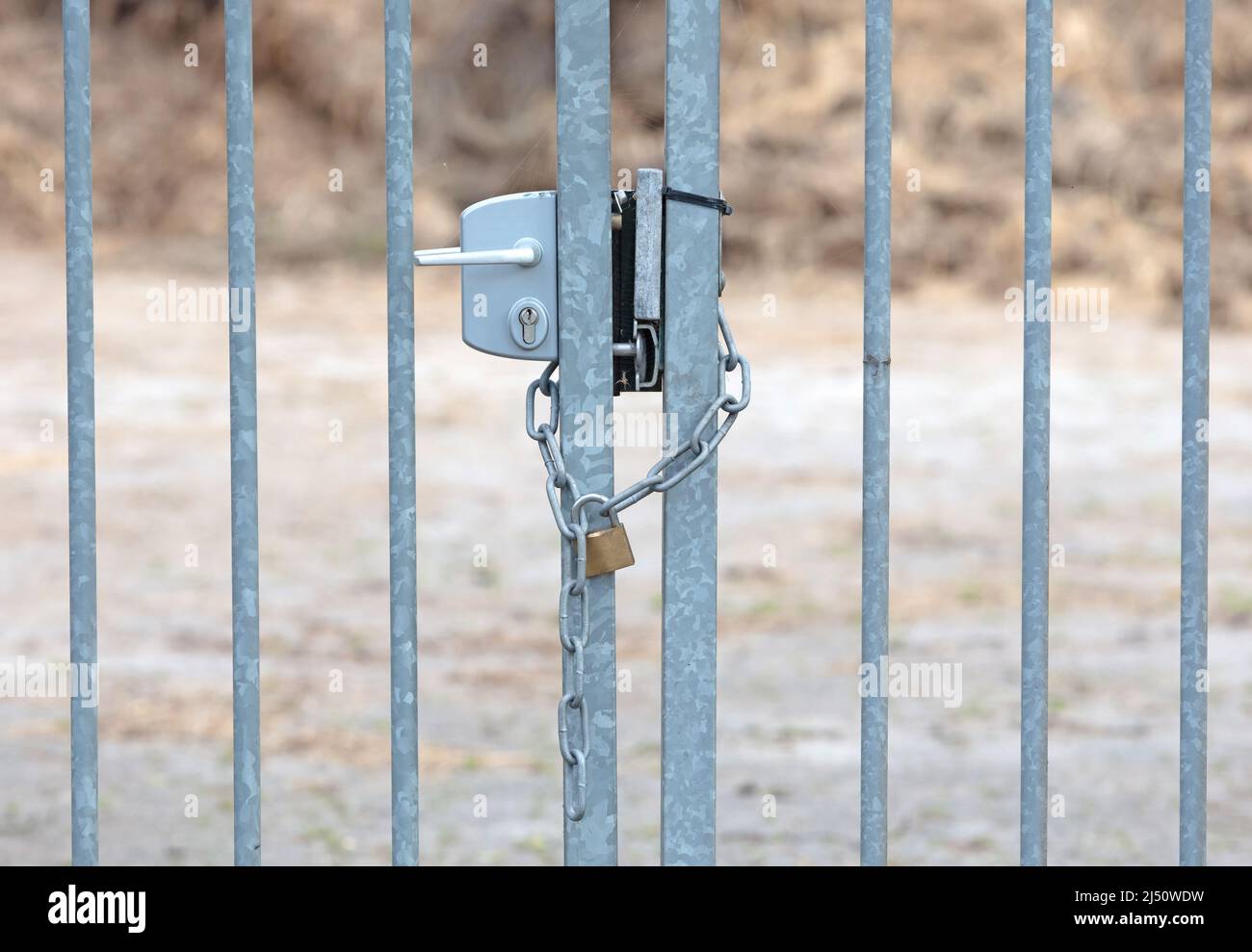 Large metal fence locked with a padlock and a chain, selective focus ...