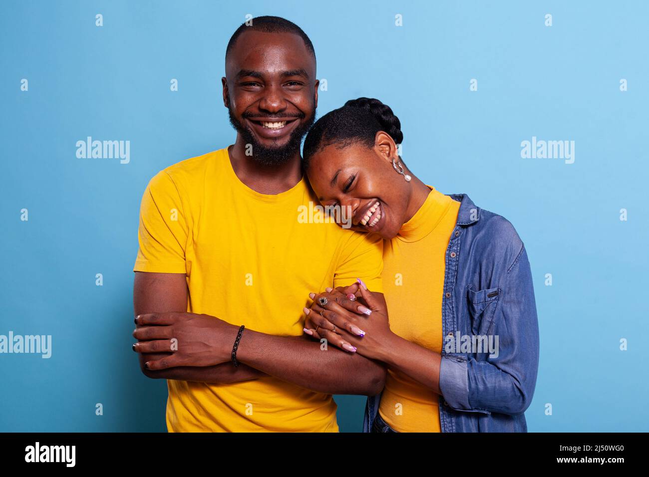 Smiling lovers holding hands and bonding in studio, showing affection ...