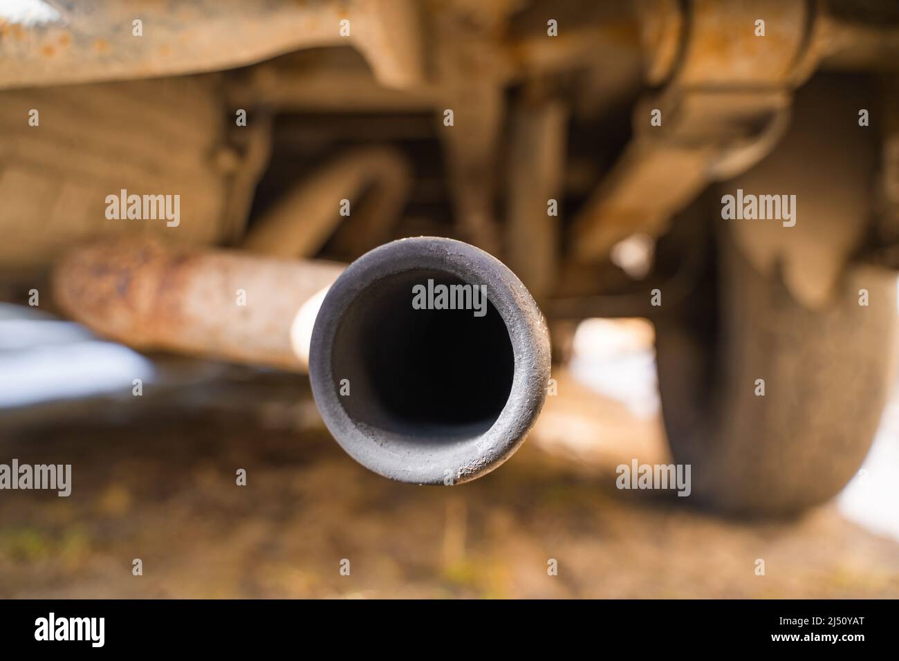 Rusty exhaust pipe with soot close-up. The spare tire is installed from ...