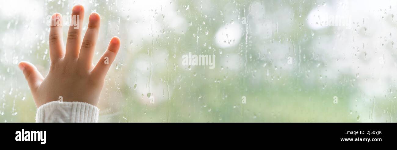 partial view of child touching wet window glass, banner Stock Photo - Alamy