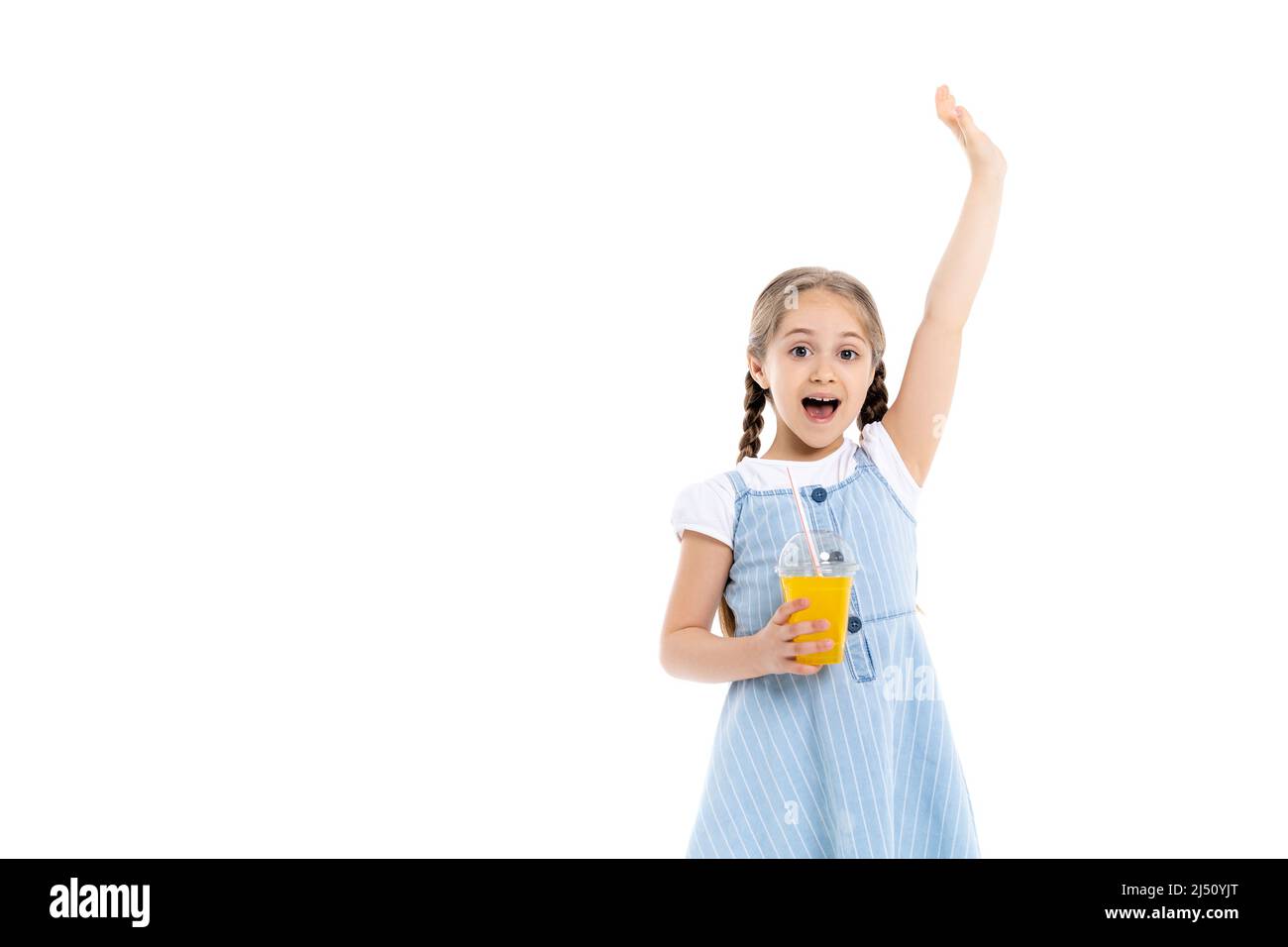 excited girl with orange juice standing with raised hand and screaming ...