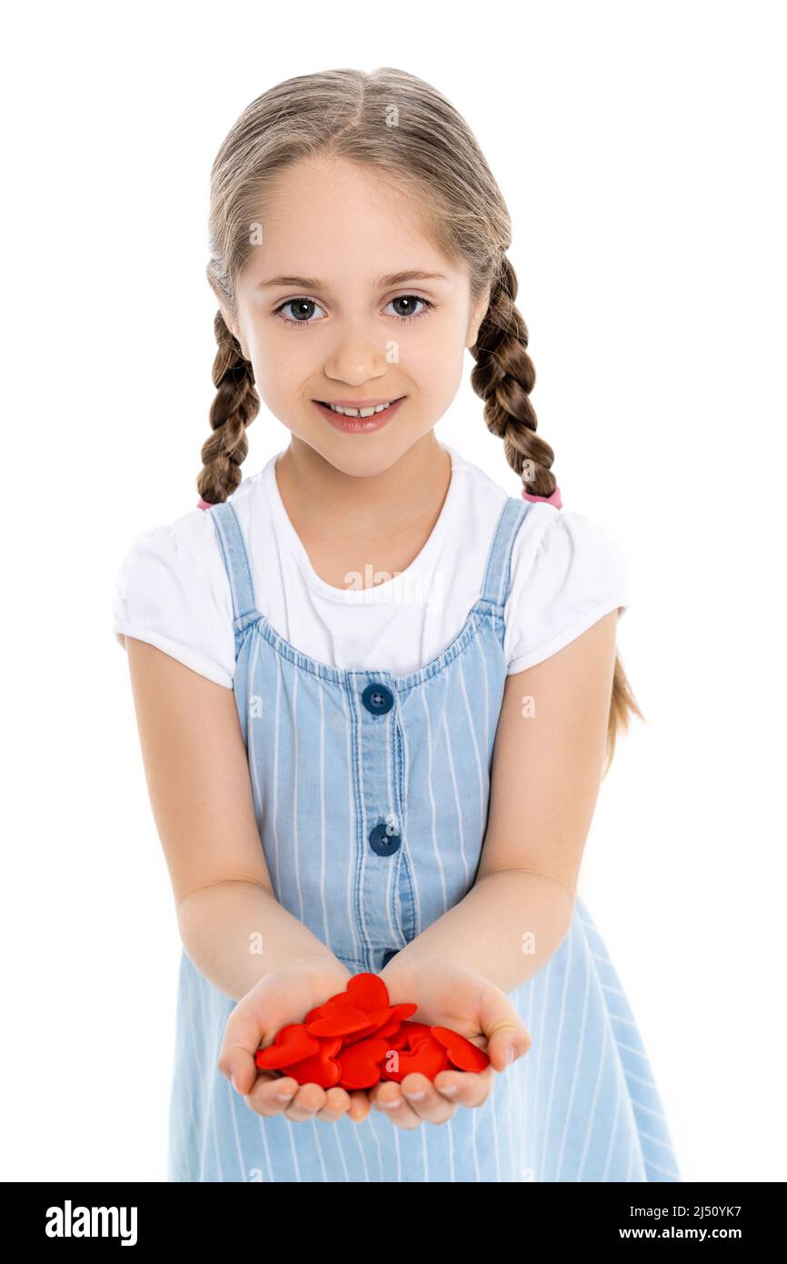 cheerful child showing handful of red toy hearts isolated on white ...