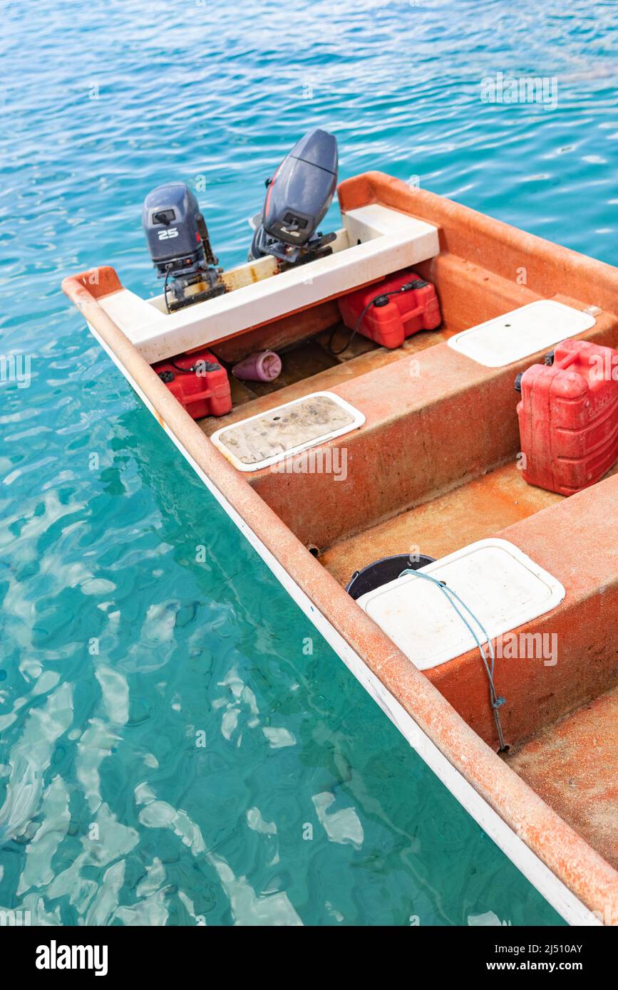 Small orange and white fishing boat on the crystal clear, turquoise ...