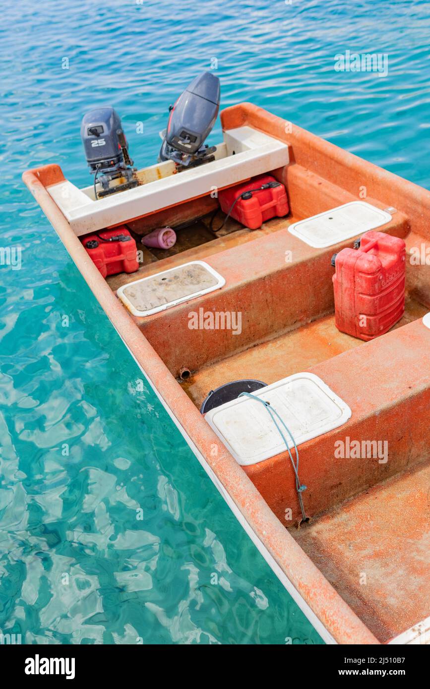 Small orange and white fishing boat on the crystal clear, turquoise ...