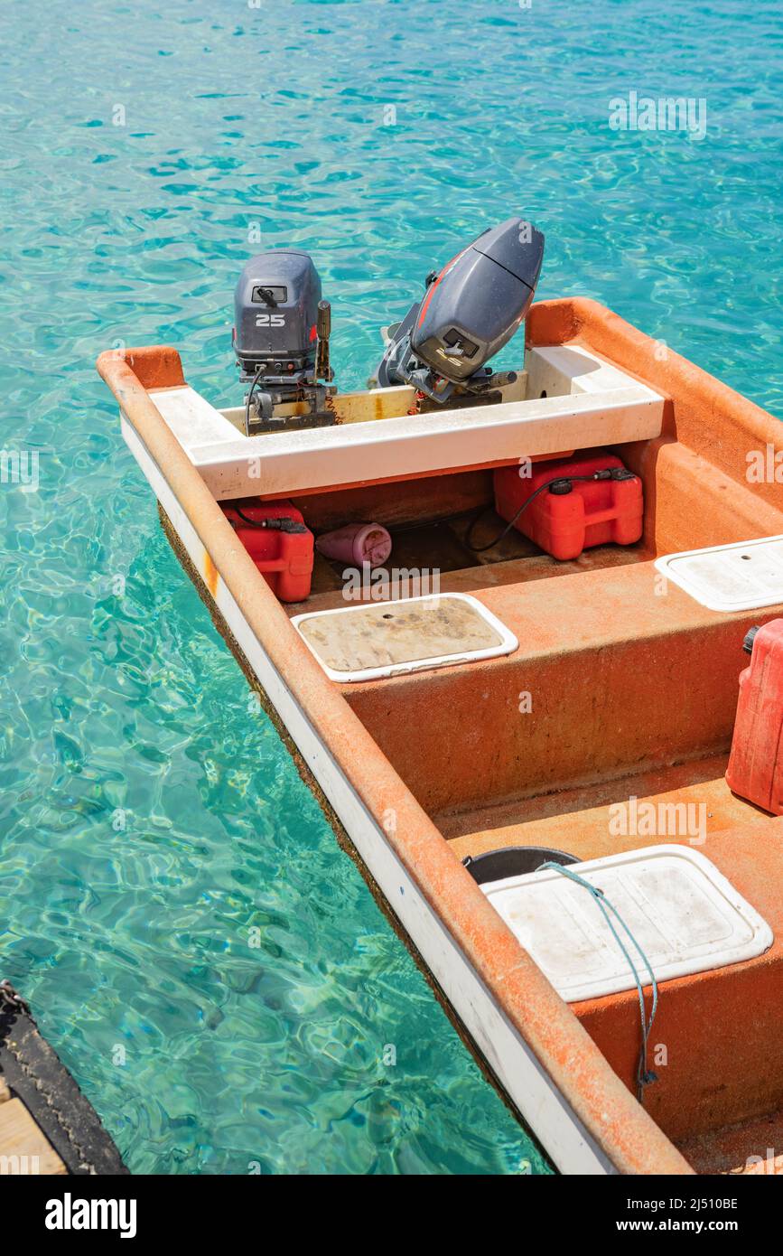 Small orange and white fishing boat on the crystal clear, turquoise ...