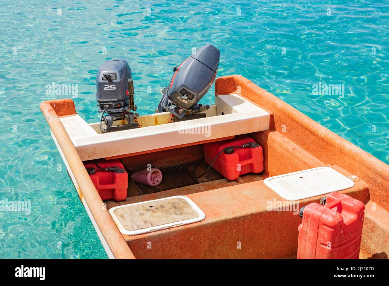 Small orange and white fishing boat on the crystal clear, turquoise ...