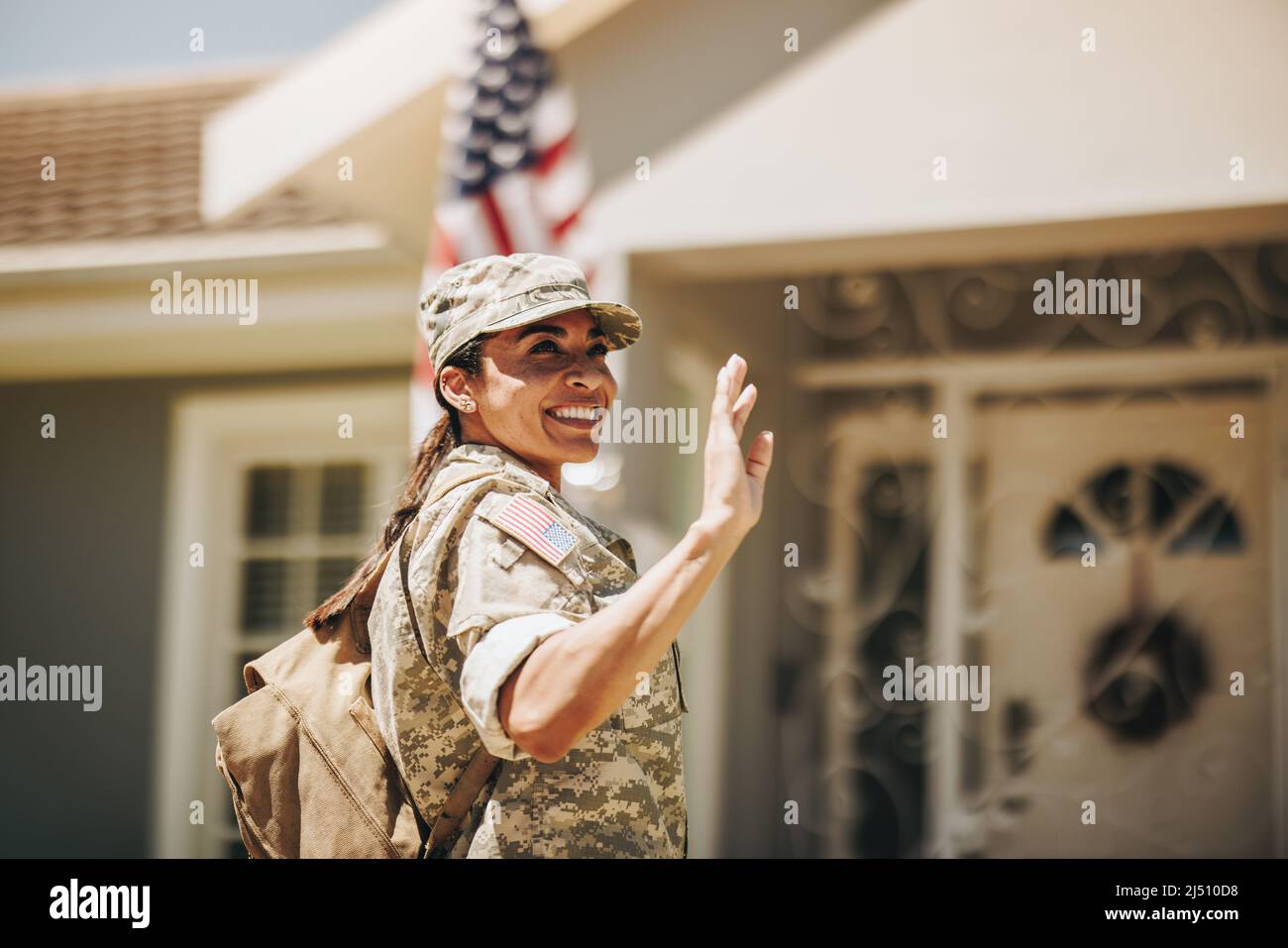 Happy female soldier smiling and waving her hand proudly while standing ...