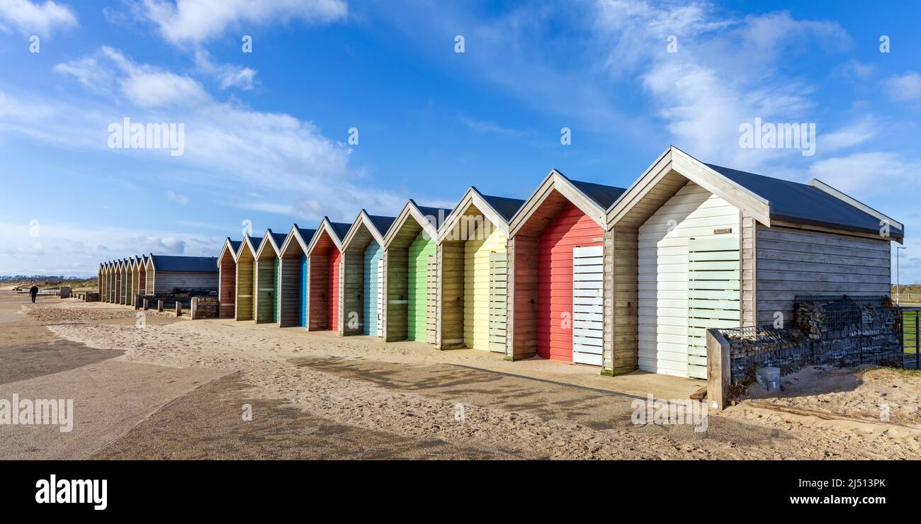 Colourful beach huts against the blue sky and white fluffy clouds at ...