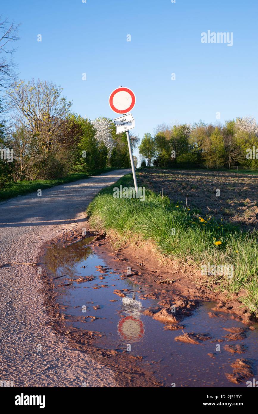 Path in the countryside, warning sign for cars, no enty, puddle after ...