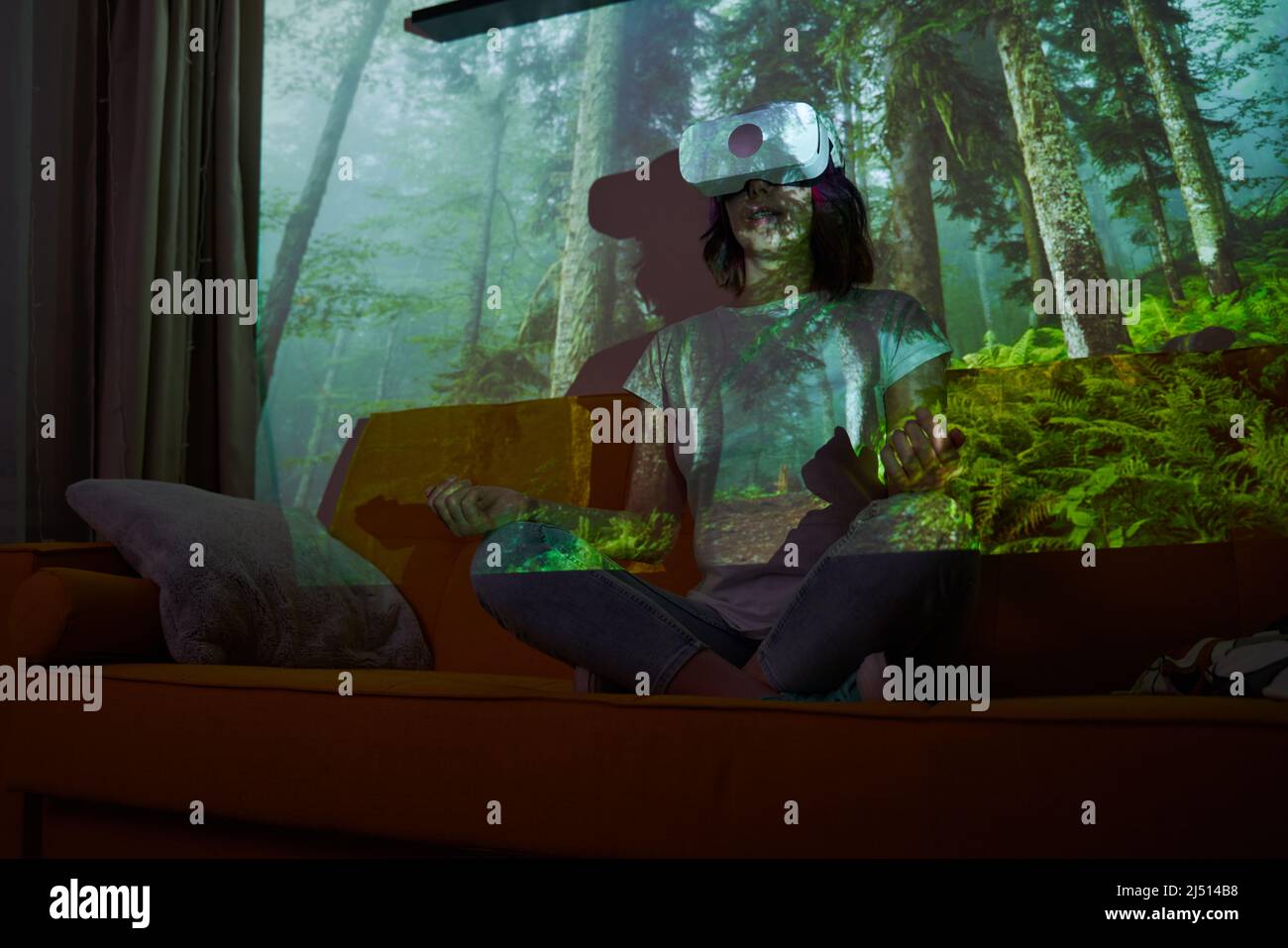 Woman uses virtual reality glasses to meditate in the forest. The ...
