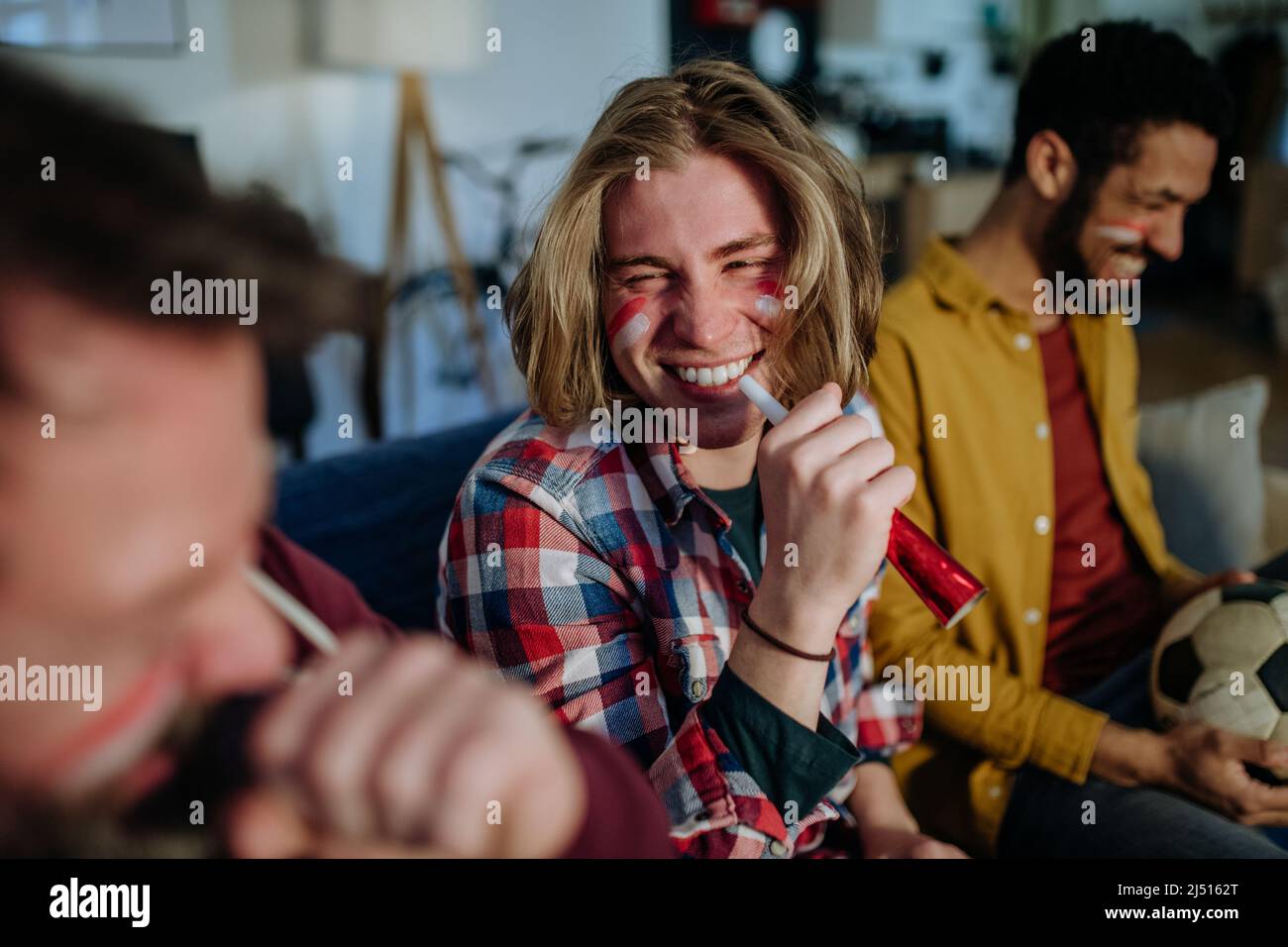 Happy Austrian football fans friends watching football at home and ...