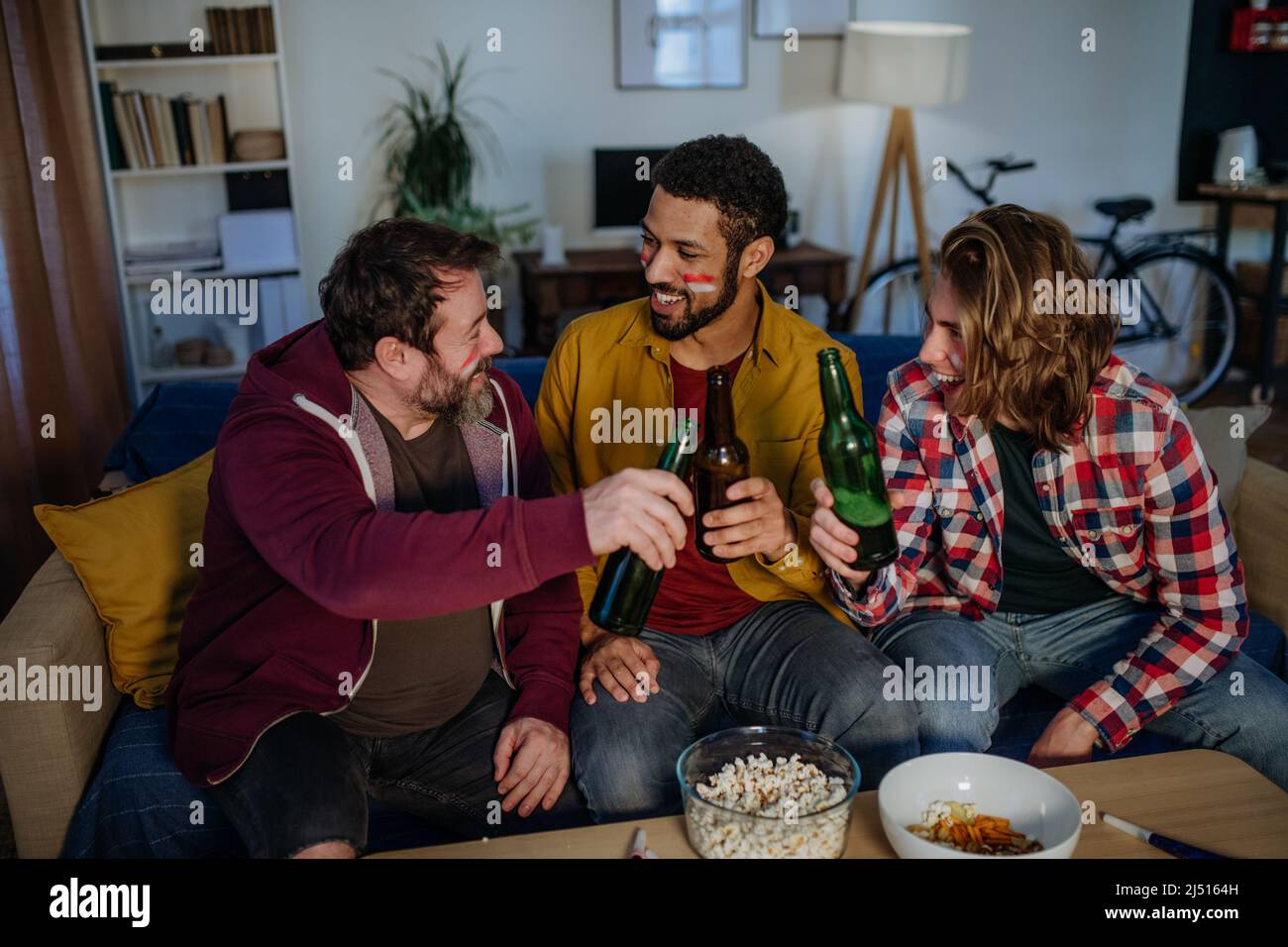 Happy Austrian football fans friends watching football at home and ...