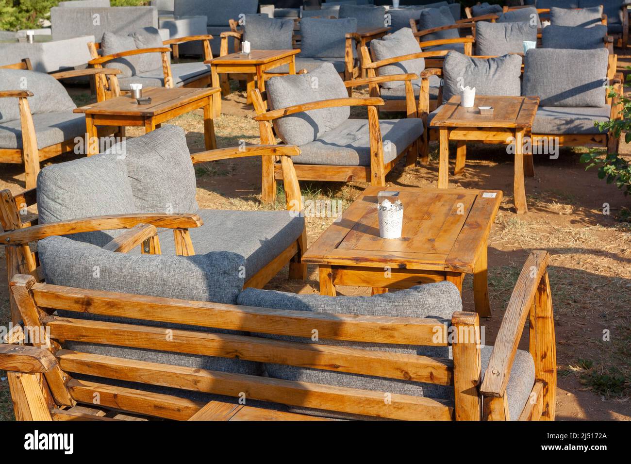 Wooden tables and benches with soft gray cushions in cafe. Horizontal ...
