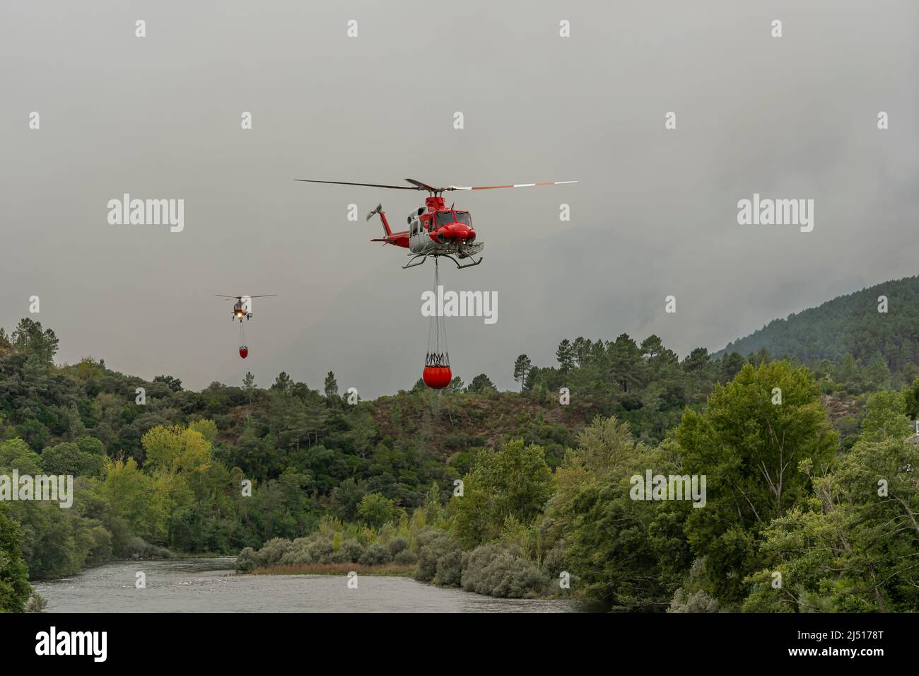 Firefighting Helicopter Carries Bucket Of Water To Extinguish Forest