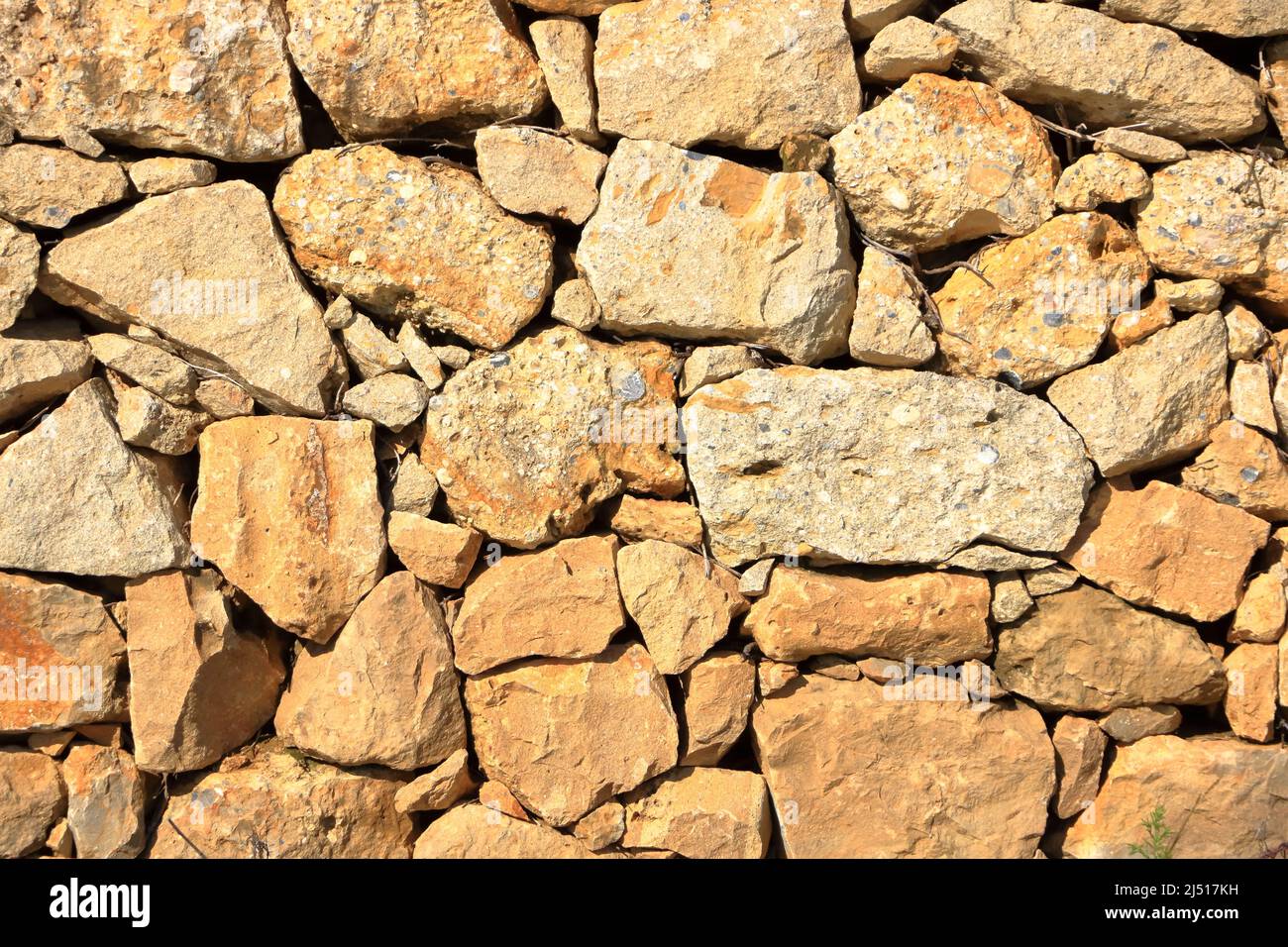 An Old yellow brown masonry wall of stones Stock Photo - Alamy