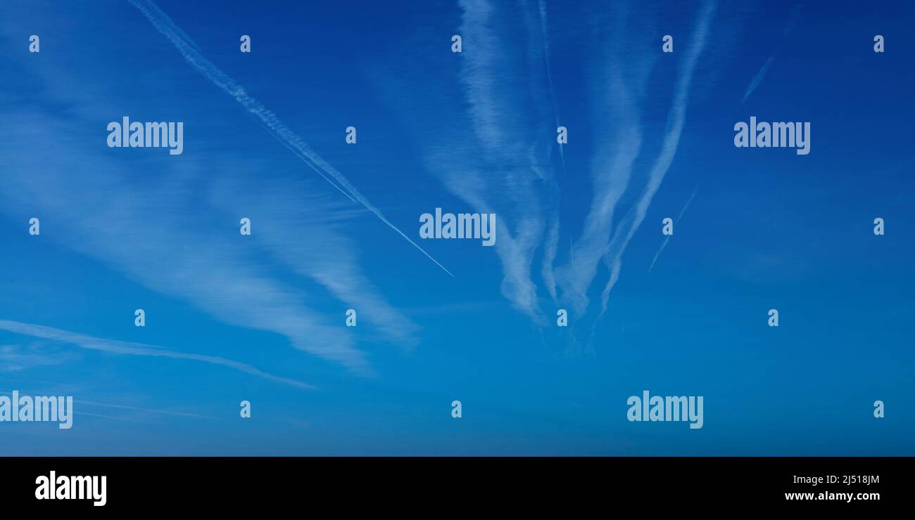 Airplane contrail against blue sky with white cloud. Jet plane ...