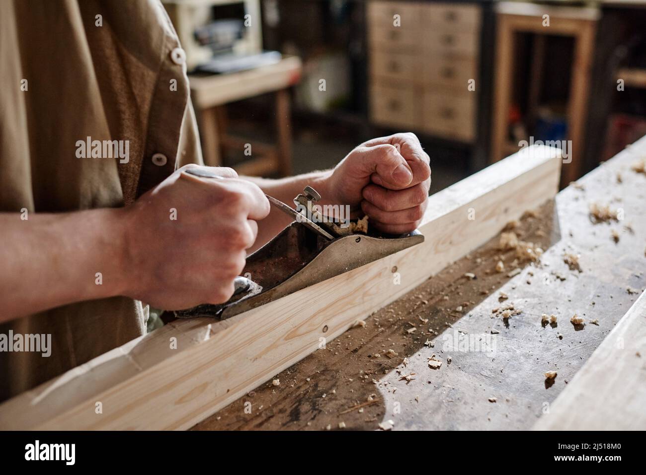 Medium close-up of unrecognizable carpenter working in workshop using ...