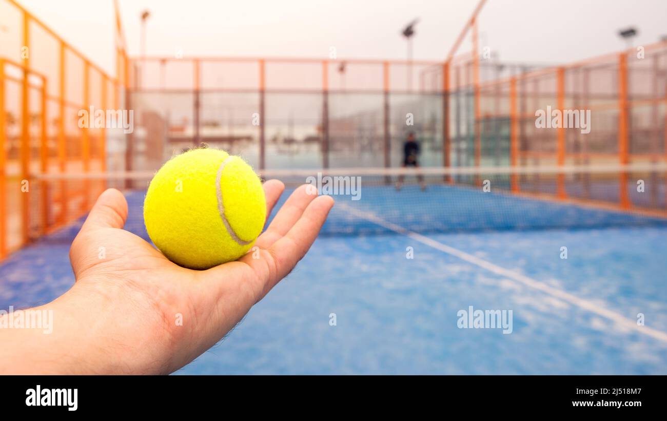 Trainer teaches paddel to male student on outdoor tennis court. Man ...