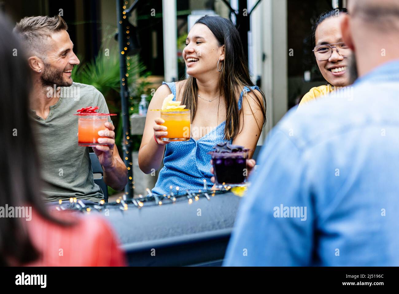 Happy millennial friends toasting trendy cocktails at pub terrace in ...