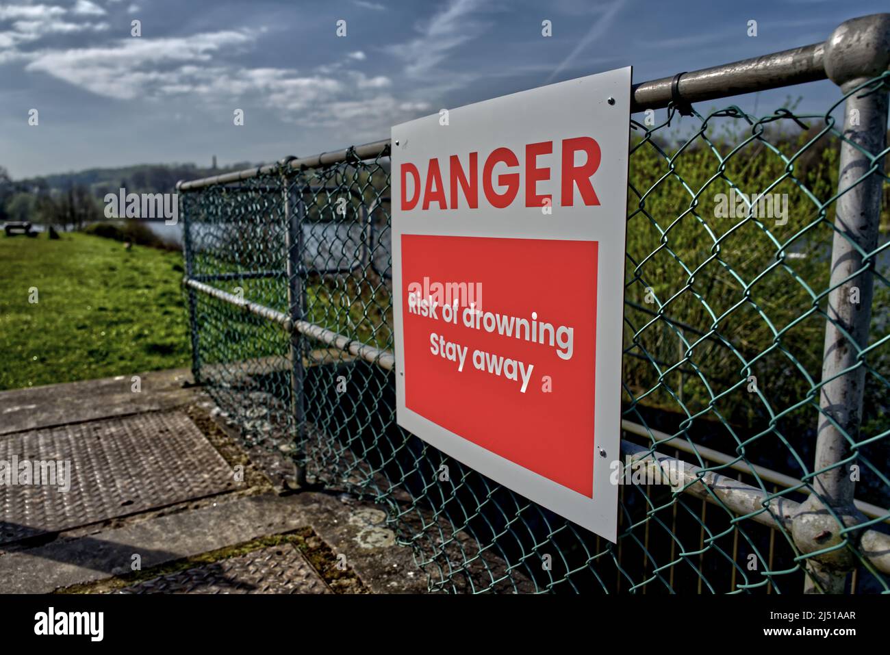 Danger risk of drowning signs and lifebouy with rope alongside open ...