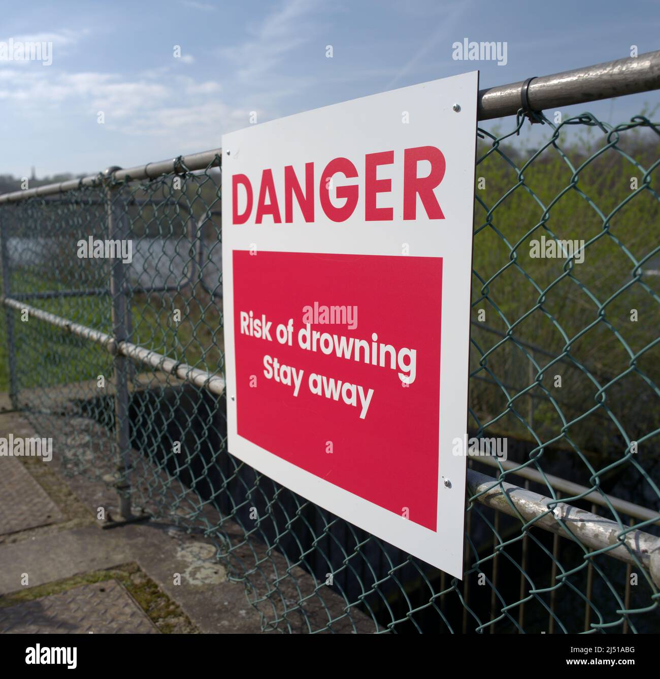 Danger risk of drowning signs and lifebouy with rope alongside open ...