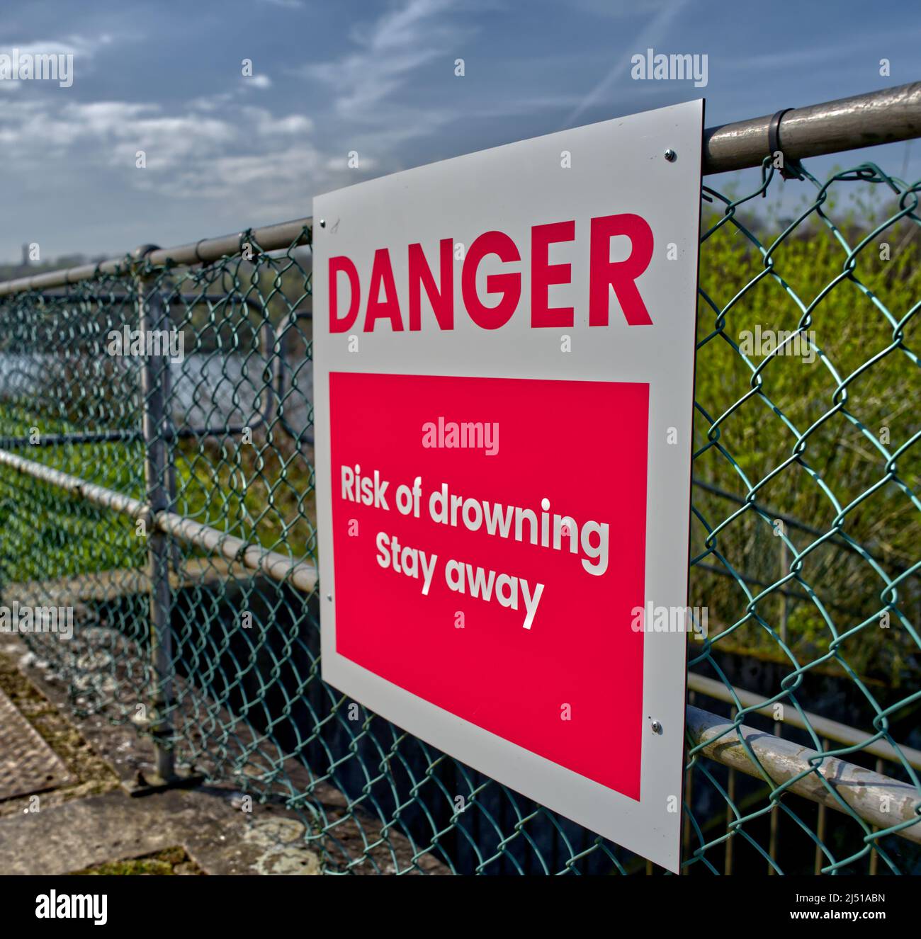 Danger risk of drowning signs and lifebouy with rope alongside open ...