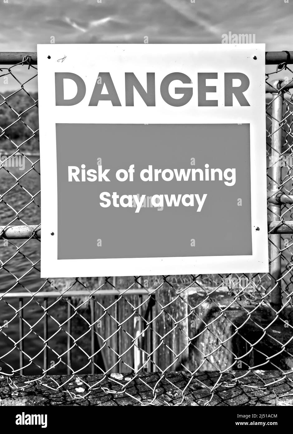 Danger risk of drowning signs and lifebouy with rope alongside open ...
