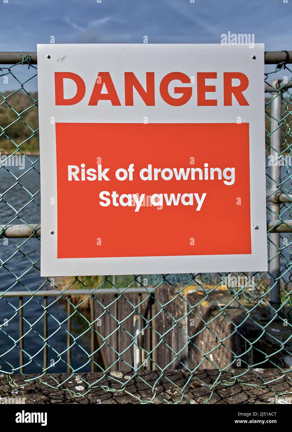 Danger risk of drowning signs and lifebouy with rope alongside open ...