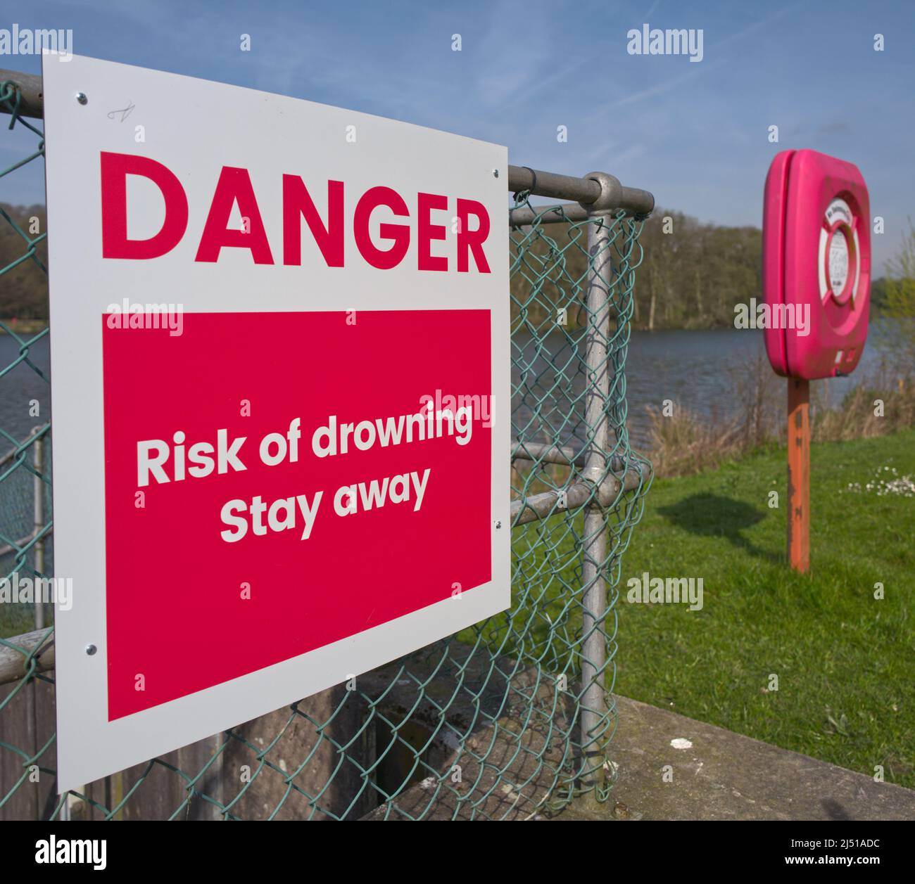 Danger risk of drowning signs and lifebouy with rope alongside open ...