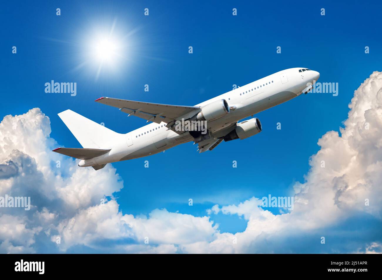 White wide body passenger aircraft is climbing in the air above scenic ...