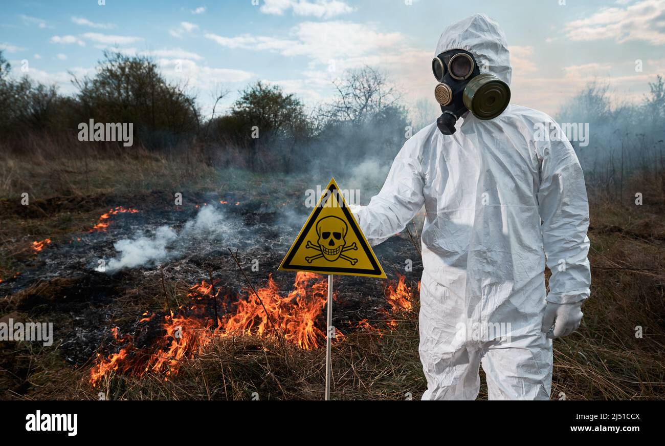 Firefighter working in field with wildfire. Man in protective suit and ...